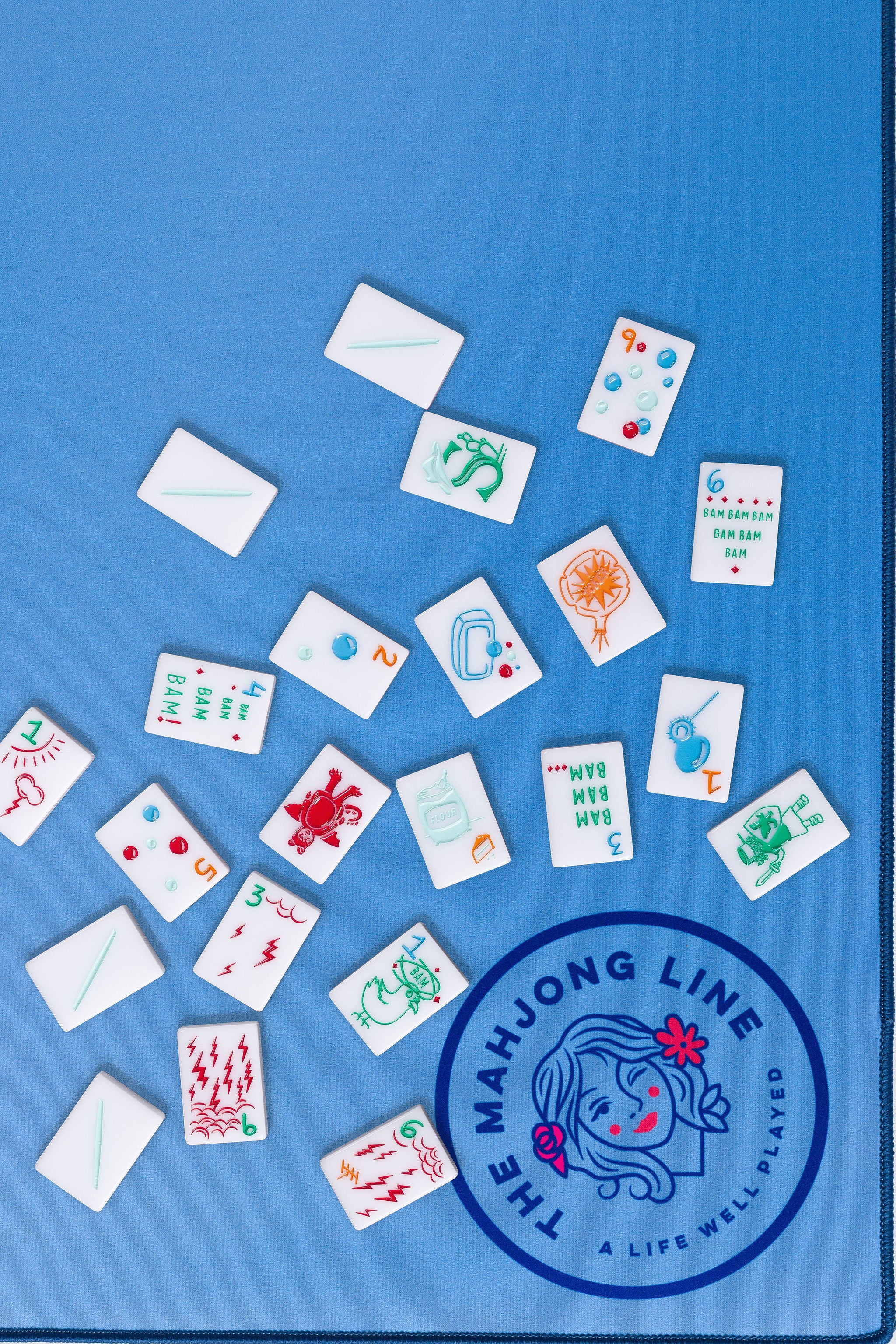 Light blue game mat paired with mahjong tiles– The Mahjong Line